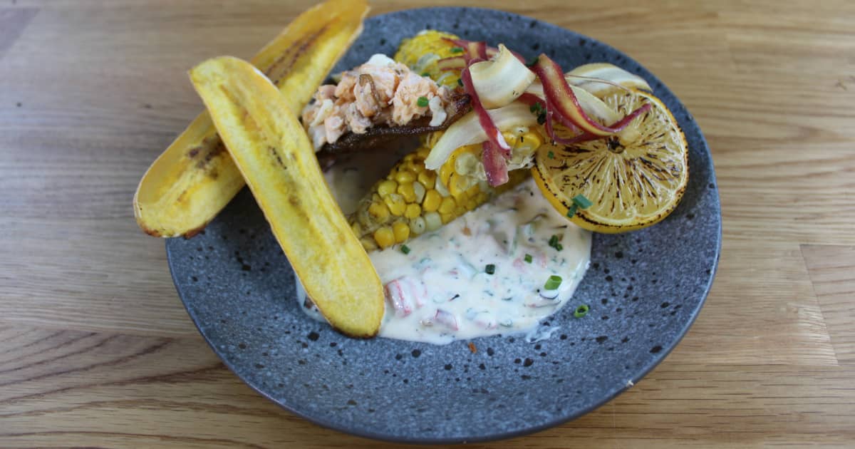 Truite grillée, maïs boucané, chips de plantain et peau de poisson ...
